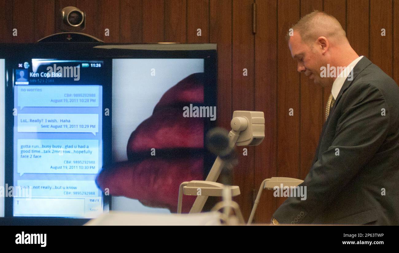 Michigan State Police Lt. Jason Teddy scrolls through text messages ...