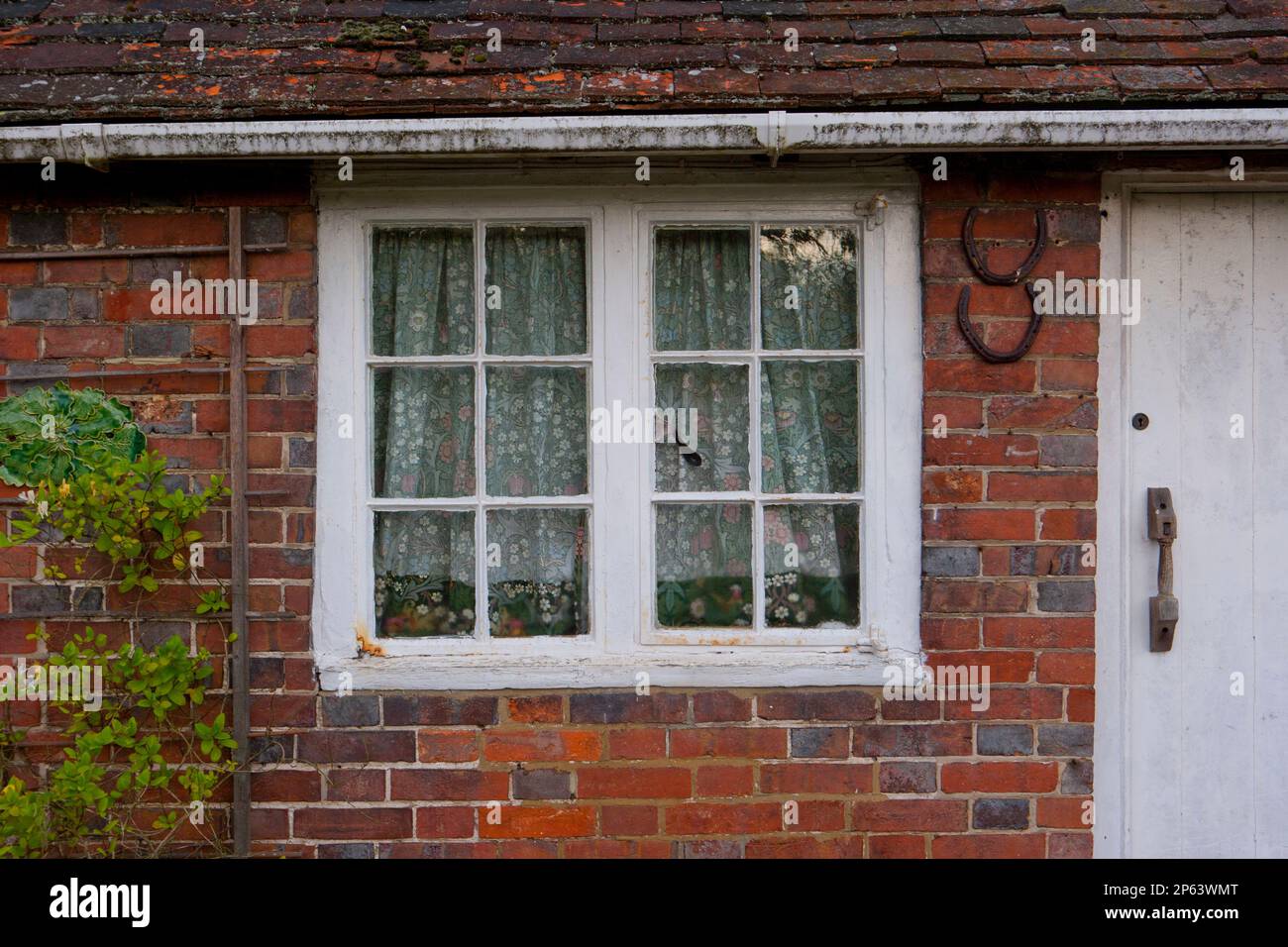 Old country brick cottage white-paned windows with floral curtains ...