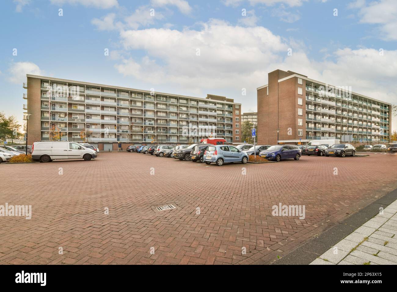 a parking area with cars parked in the lot and an apartment building on ...