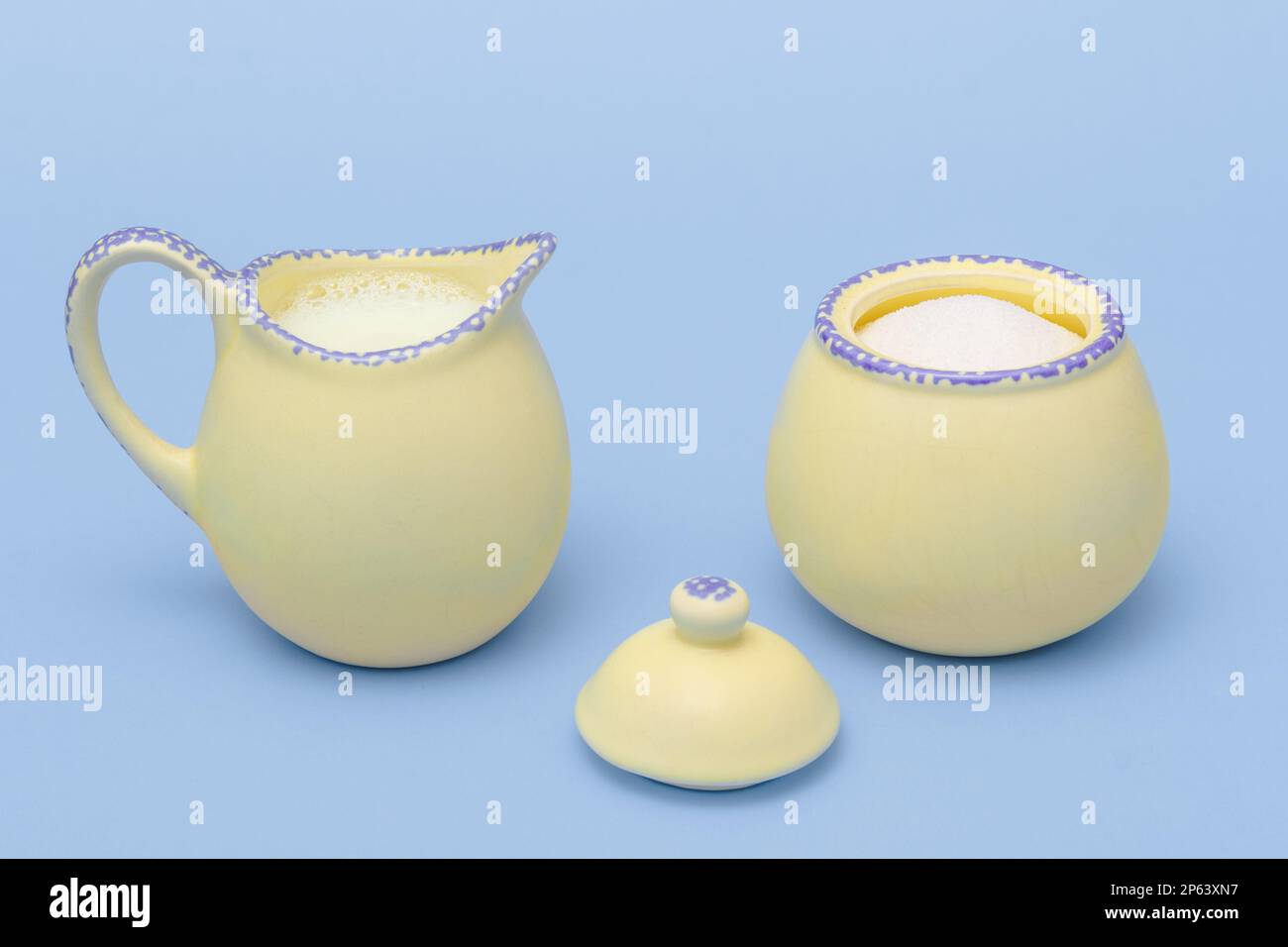 Milk creamer and sugar jar on blue Stock Photo - Alamy