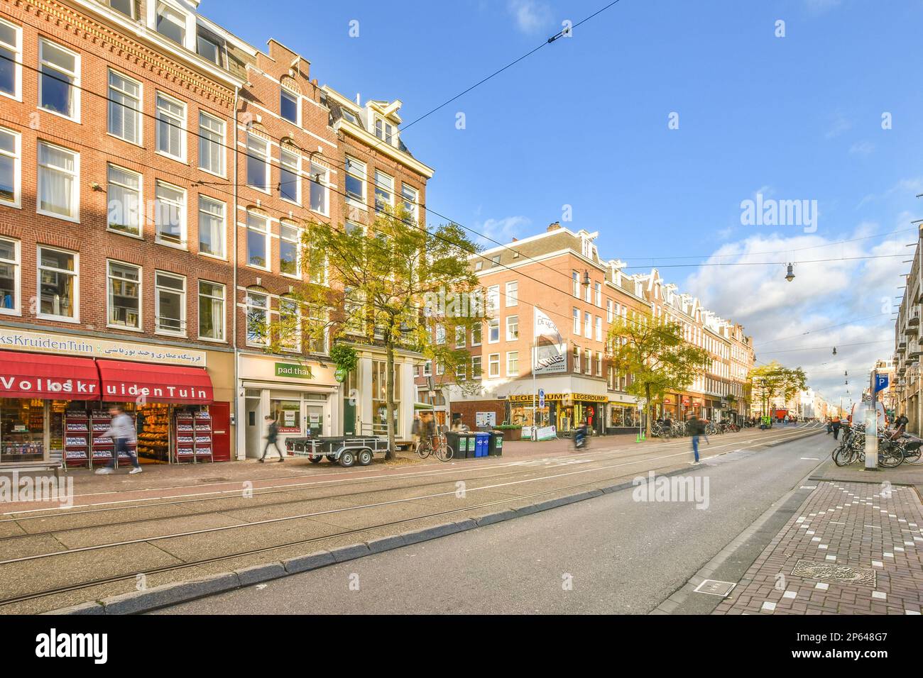 a city street with buildings on both sides and people walking down the ...