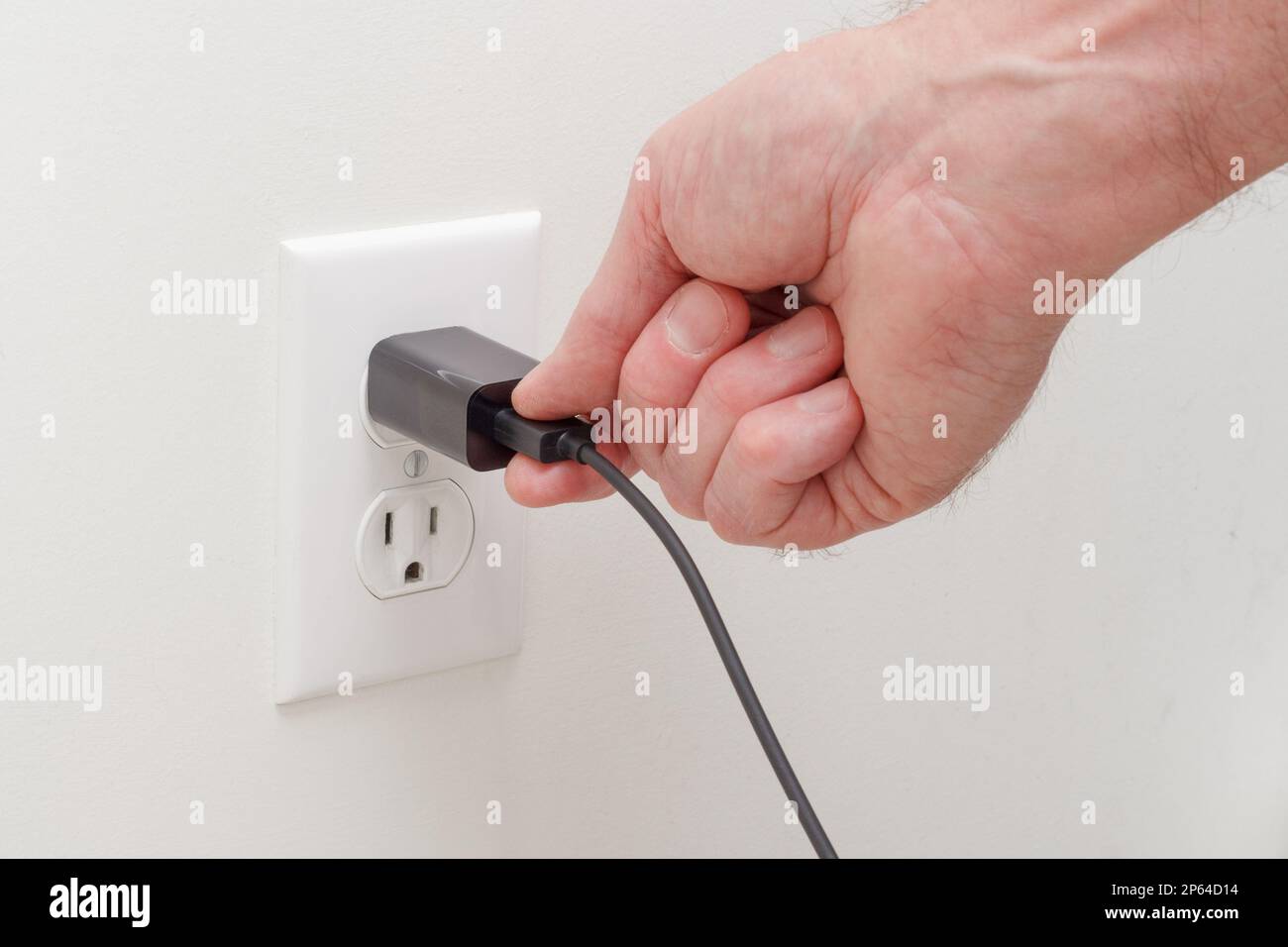 Person connecting usb adapter plug into electrical wall outlet Stock ...