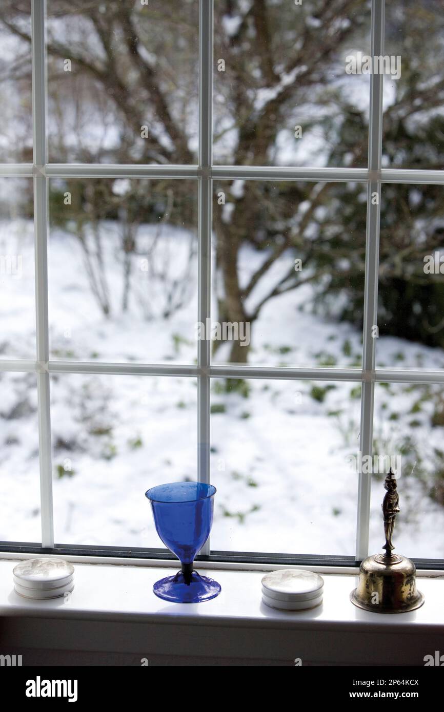collection of displayed items on windowsill looking through paned ...