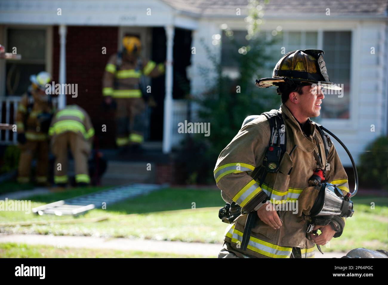 A Jackson Fire Department firefighter takes off some gear at the scene ...