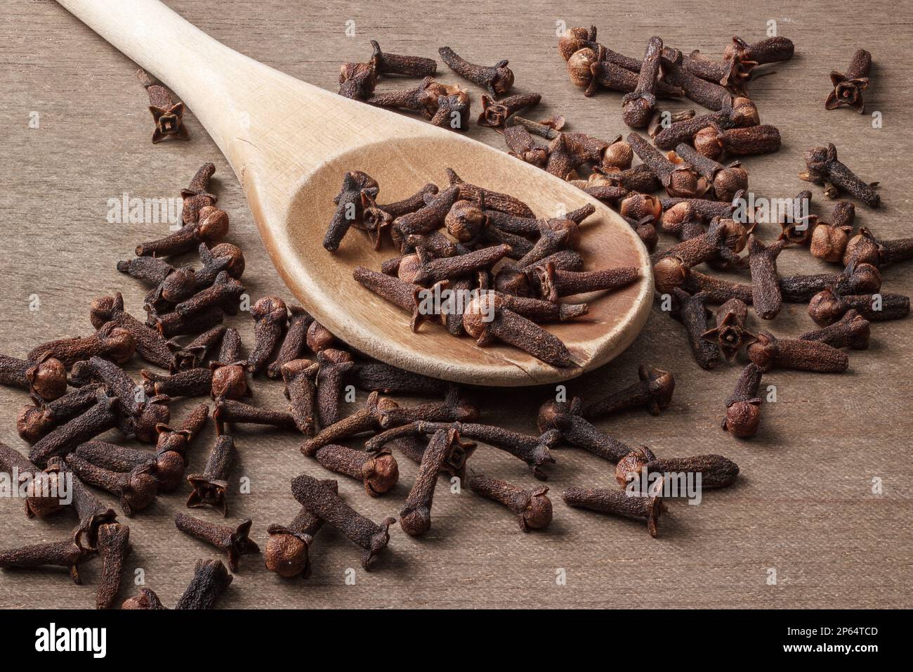 Whole cloves and spoon on wood table surface Stock Photo - Alamy