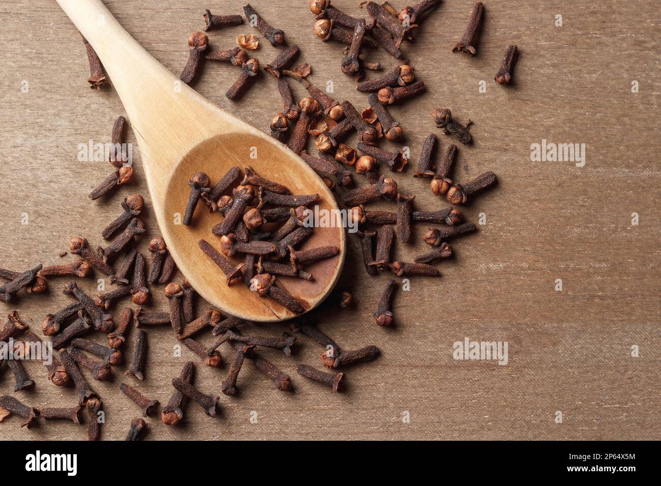 Whole cloves and spoon on wood table surface Stock Photo - Alamy
