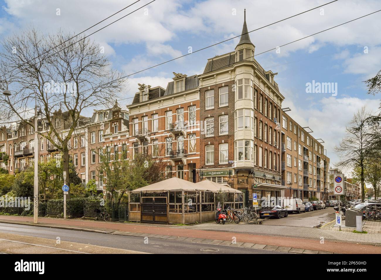 a city street with buildings and cars parked on the side of the road in ...