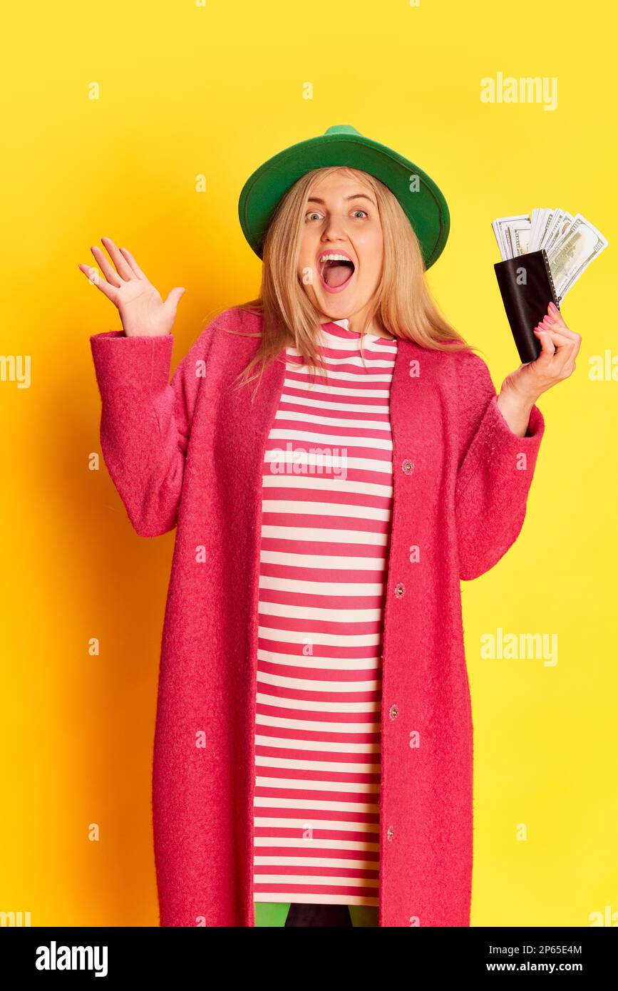 Portrait of woman in colorful clothes emotionally posing with money ...