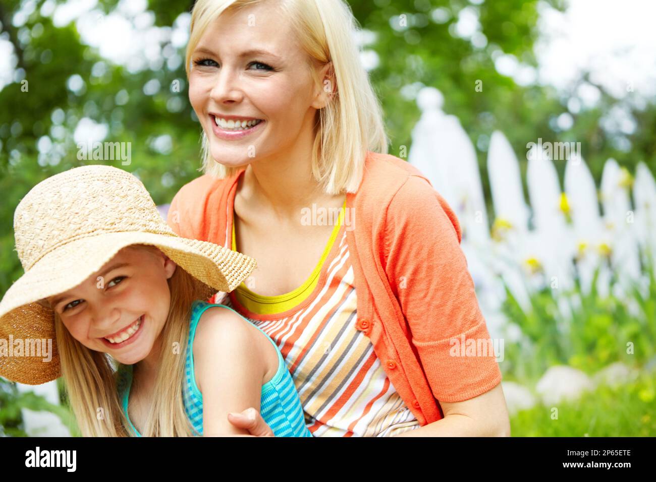 Fun in the sunshine. Cute litte girl sitting on the grass outdoors with ...