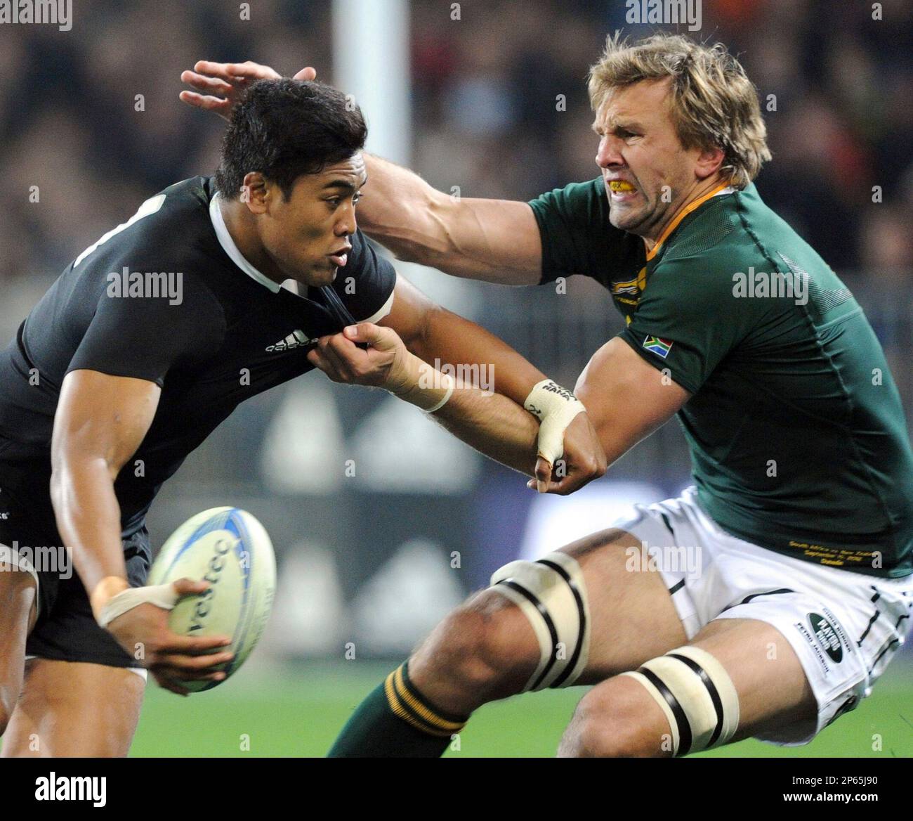 New Zealand's Julian Savea, left, is held by South Africa's Andries ...
