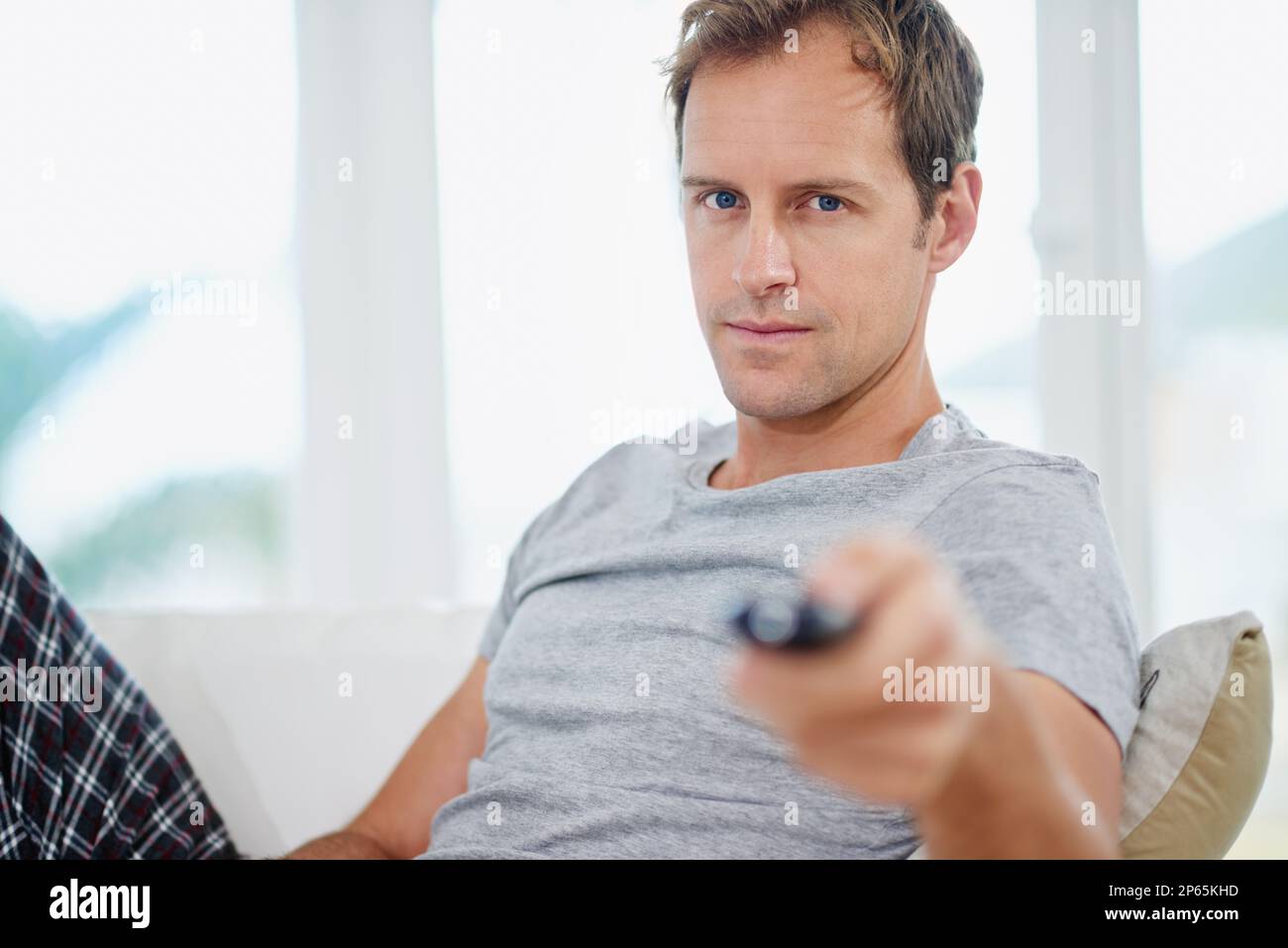 Hes serious about his weekend sport. a handsome man holding a remote ...