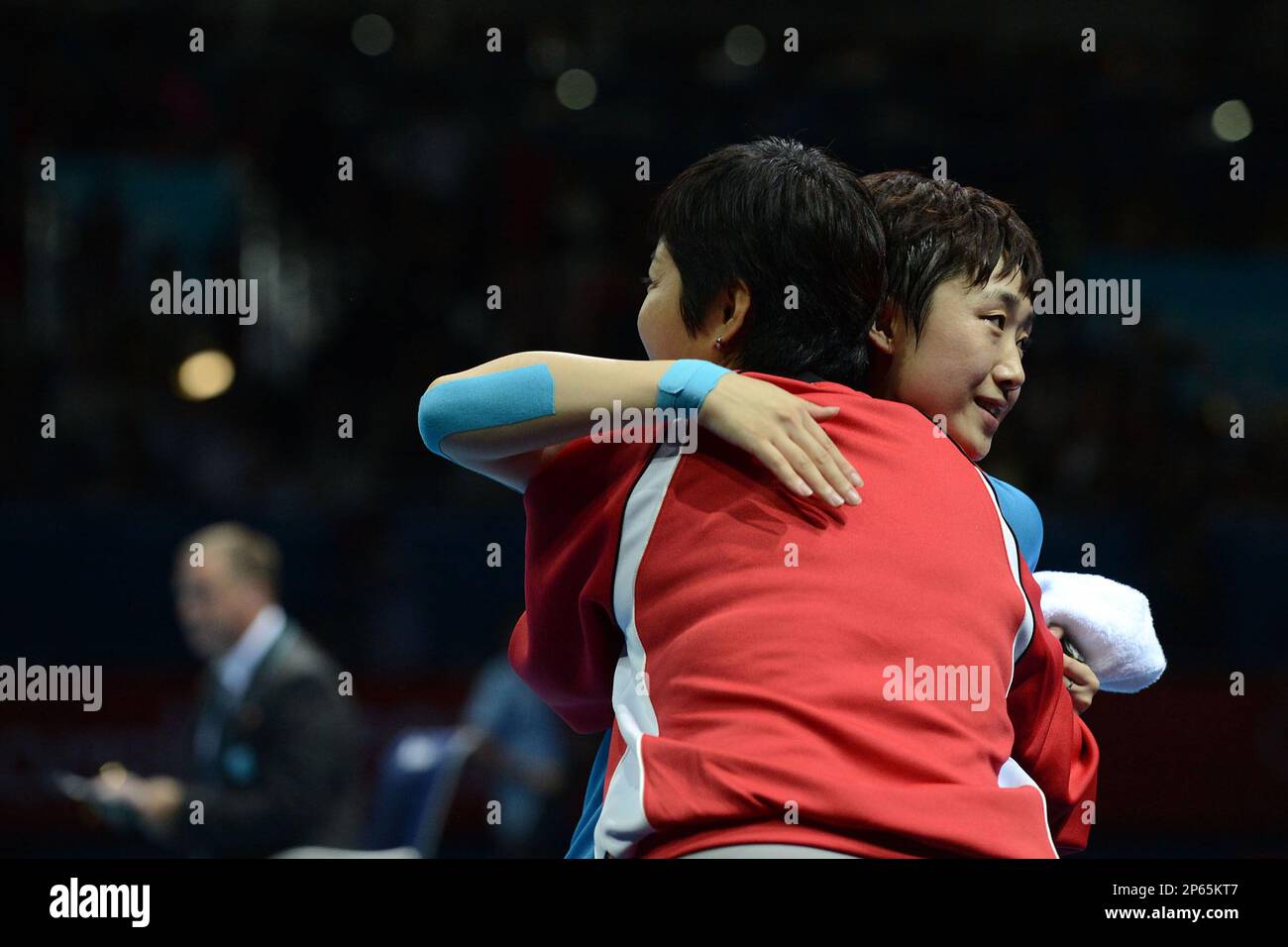 Singapore's Feng Tianwei embraces coaching Jing Junhong after she beat beat Japan's Kasumi ...