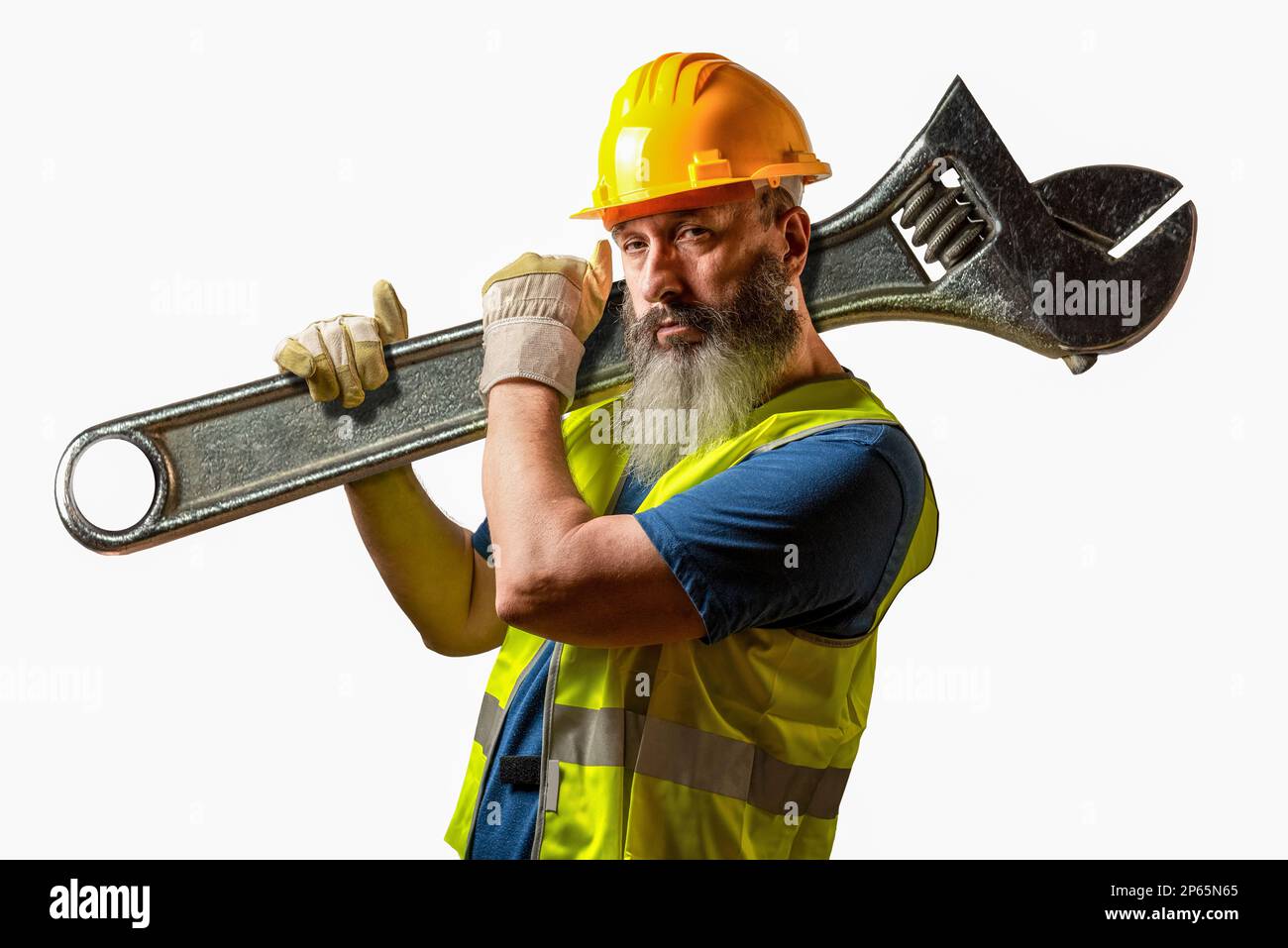 Man in helmet and yellow vest holding a giant spanner over his shoulder ...
