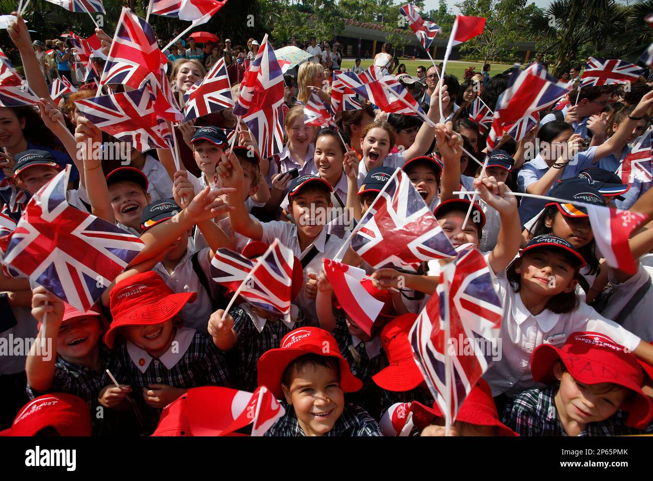 School children wave British flags as they wait for the arrival of ...