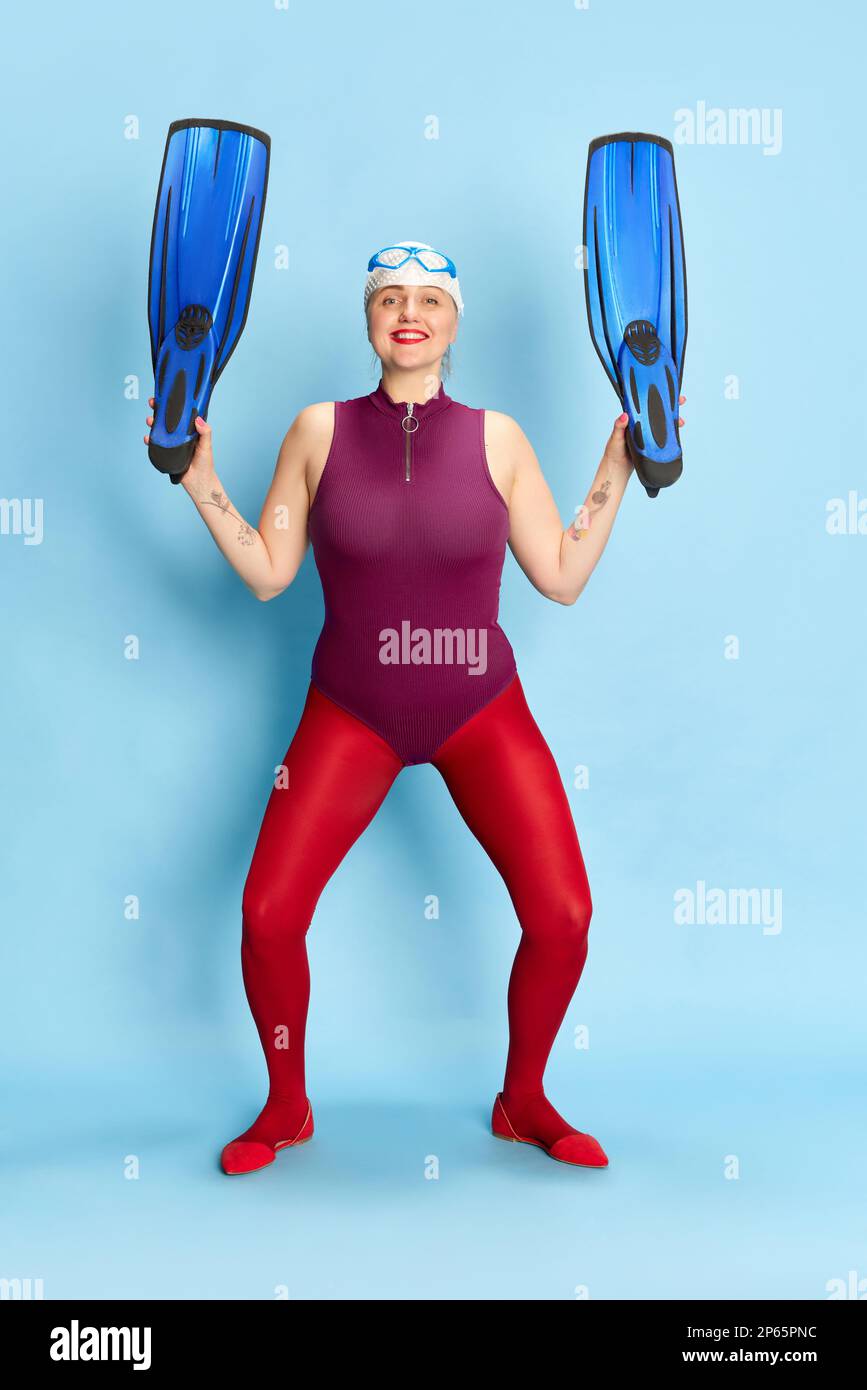 Happy swimmer. Full-length image of woman in swimming suit and red ...