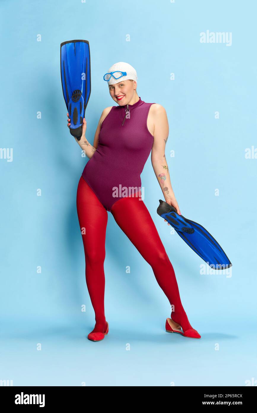 Full-length image of woman in swimming suit and red tights posing with ...