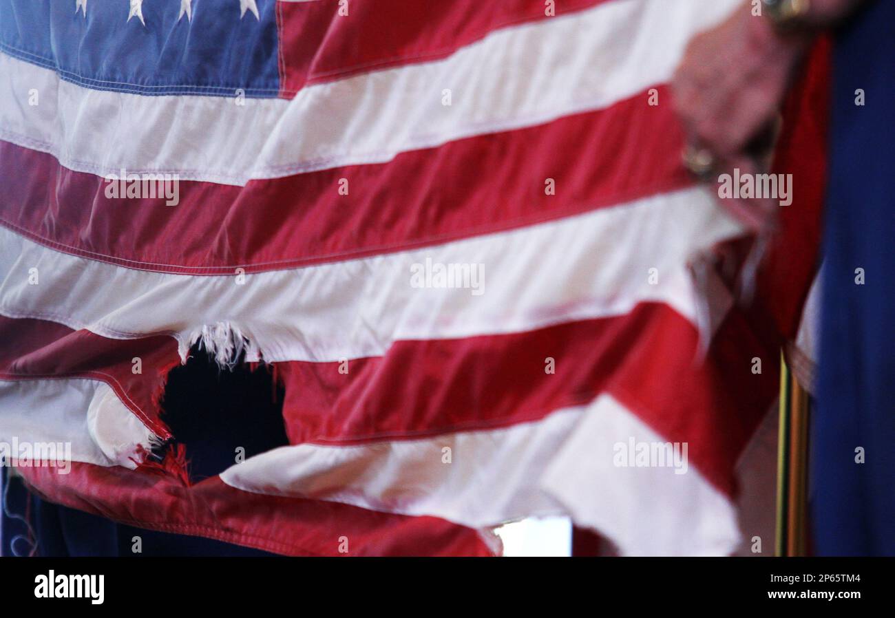 An American flag with rips and tears in it displayed during the flag ...