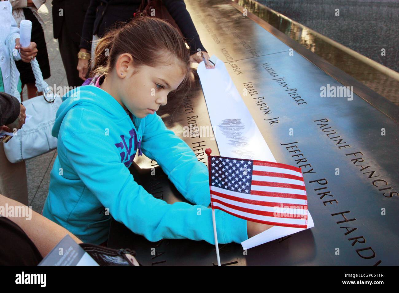 A girl makes an etching of a victim’s name at the National September ...