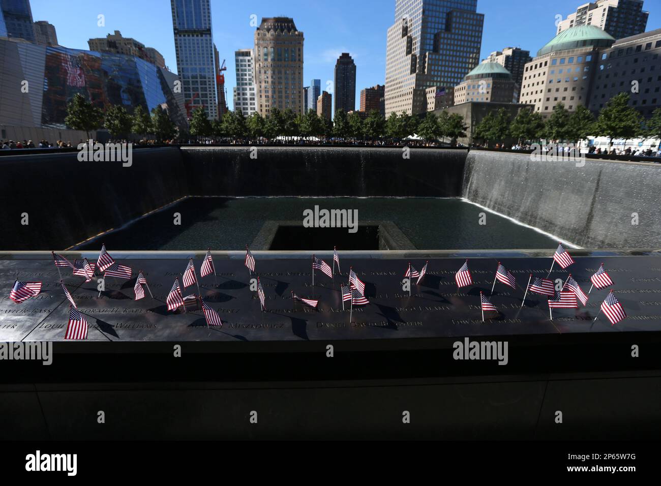 Flags are placed on a memorial during a ceremony marking the 11th ...