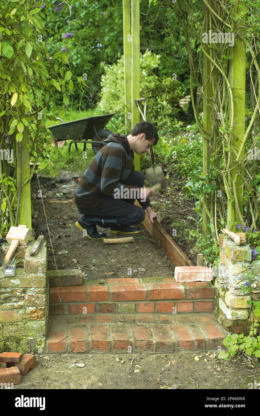 Making a brick garden pathway setting plank project 2 Stock Photo - Alamy