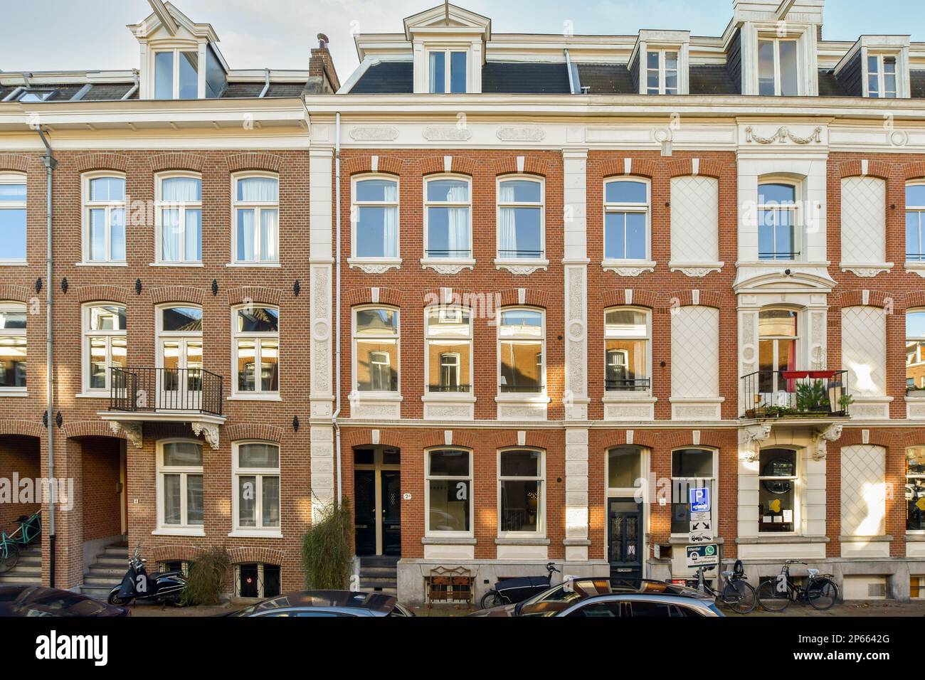 an apartment building with cars parked on the street next to it and ...