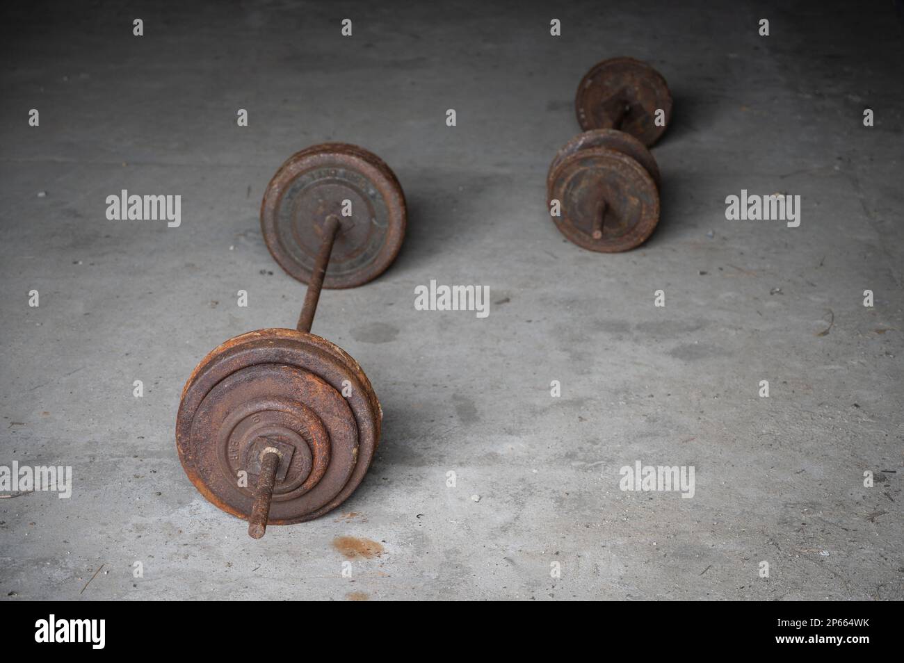 A pair of rusty and vintage dumbbells on a concrete floor Stock Photo ...