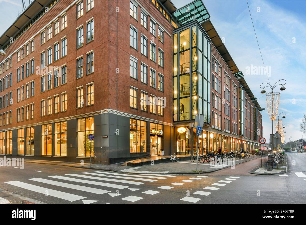 a city street with buildings and people walking on the crosswalk at an ...