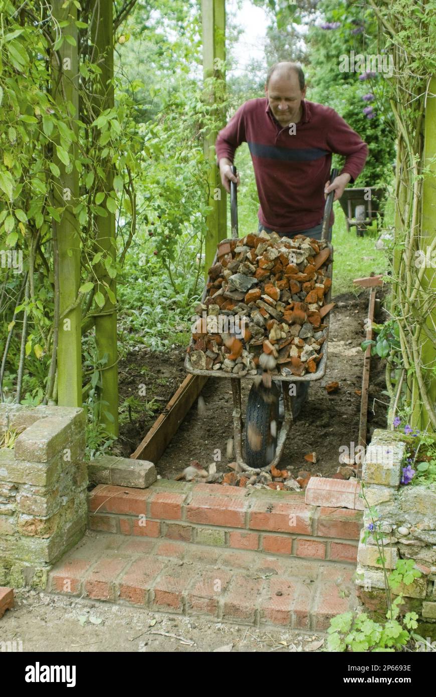 Putting layer of hardcore to create a new brick path Stock Photo - Alamy