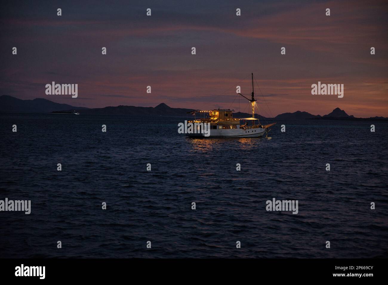 Romantic shot of glowing boat in the middle of the sea at an intense ...