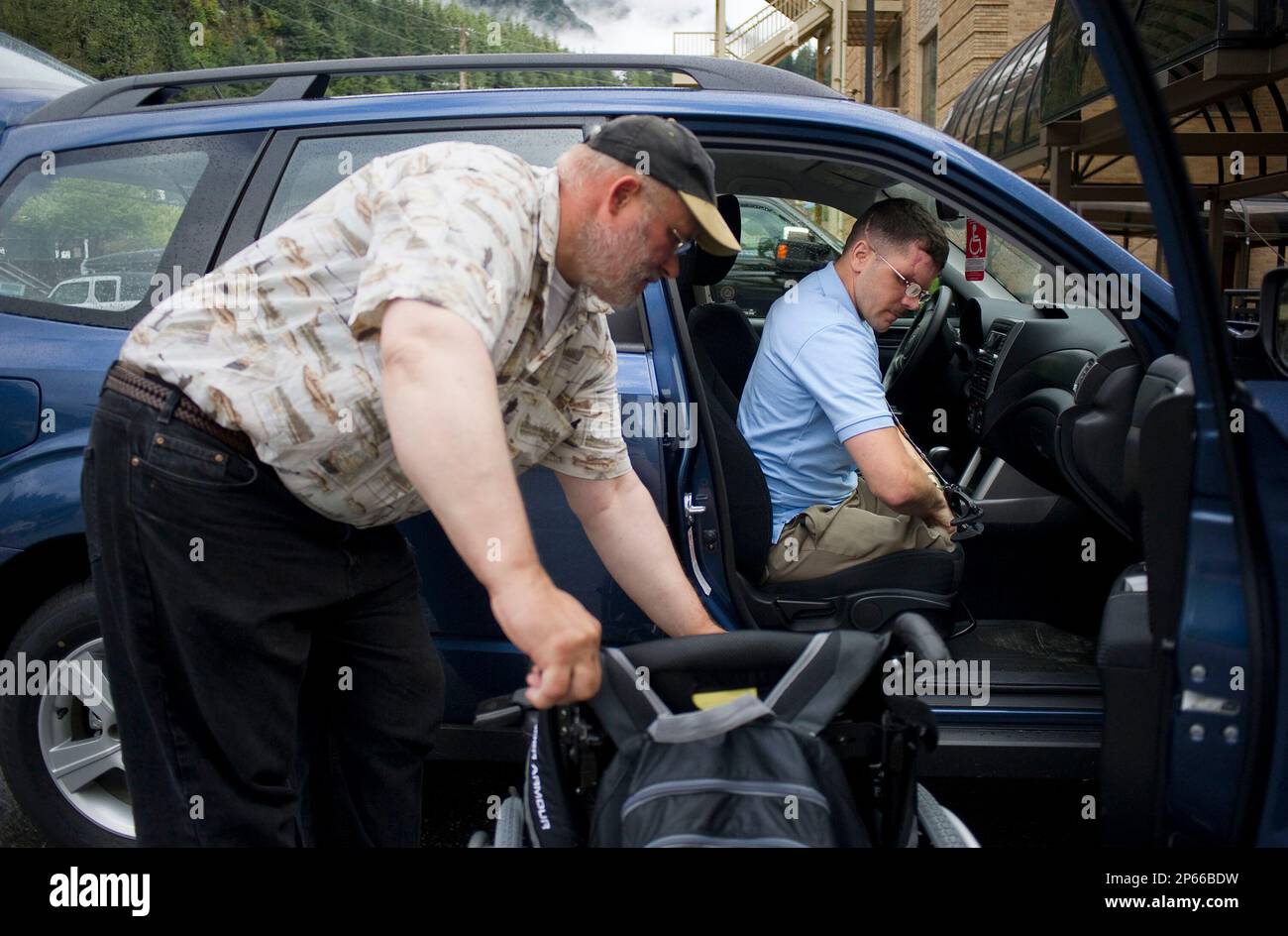 U.S. Marine Corps Staff Sgt. Thomas McRae is helped by his father, Tim ...
