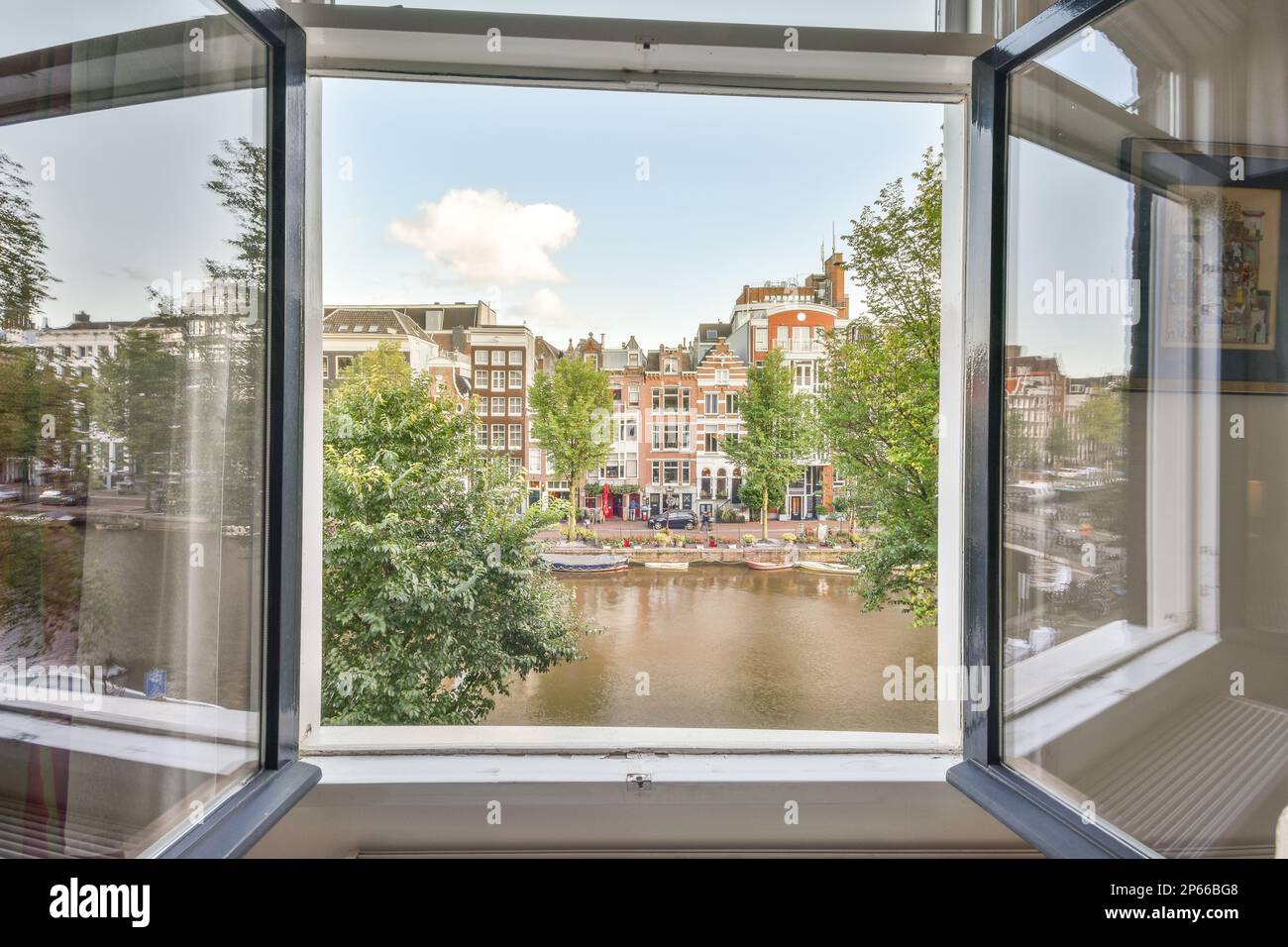 the view from an open window in a building that looks out onto a canal ...