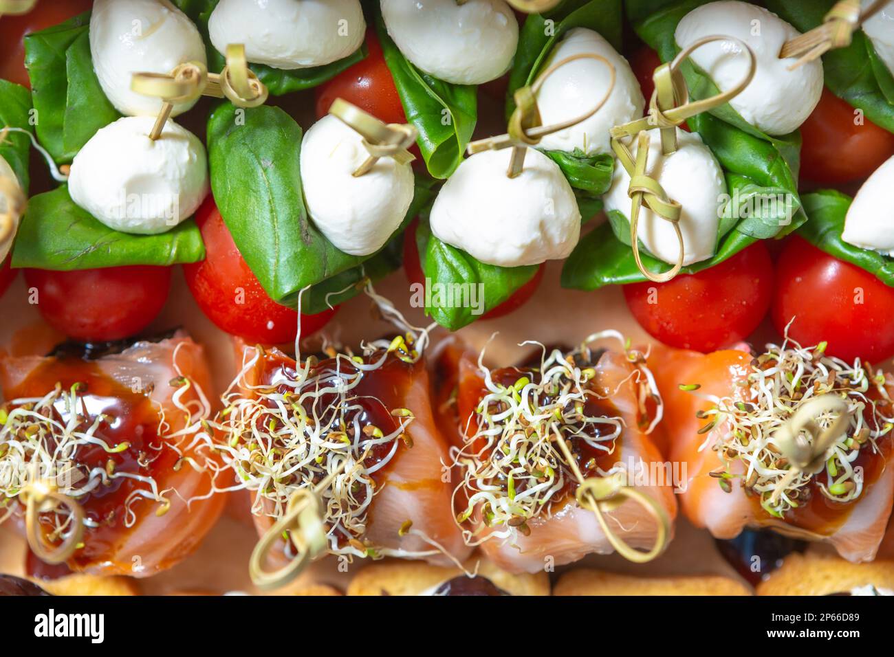Box of gourmet snacks in flat lay. Canapes with mozzarella cheese balls ...