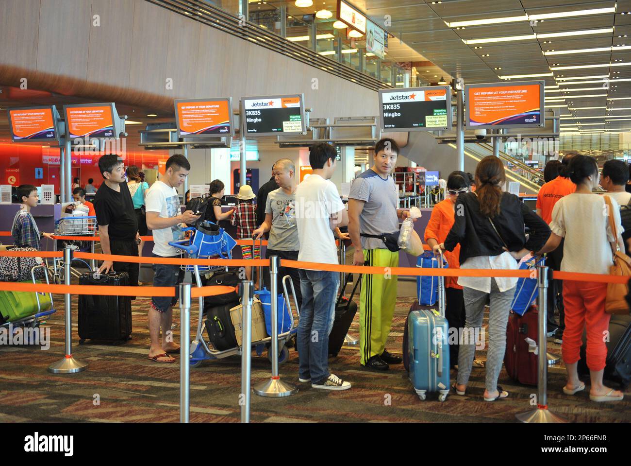 Passengers queuing up at the Jetstar counter in Changi Airport Terminal ...
