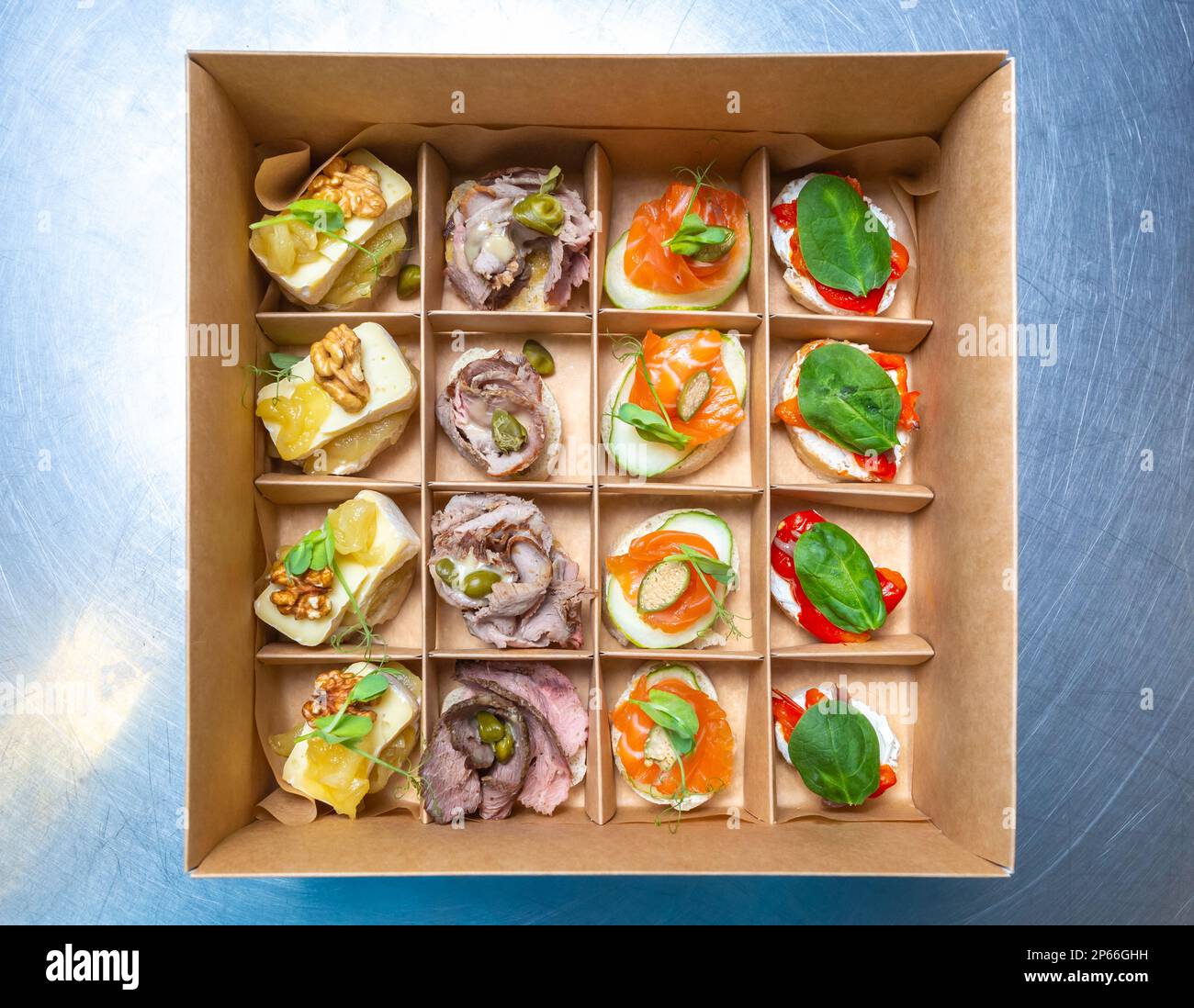 Box with snacks. Gourmet canapes with exotic ingredient delivered in ...