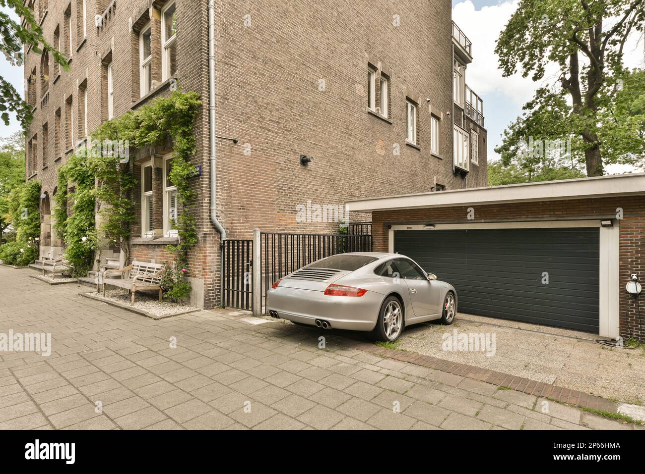 a car parked on the side of a street in front of a brick building with ...