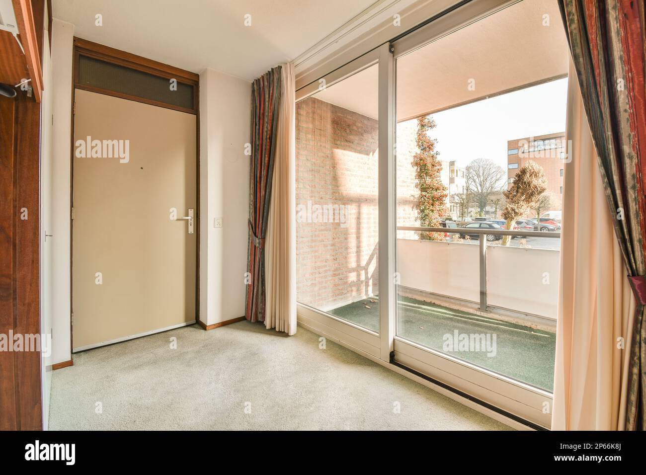 an empty room with sliding glass doors and carpeted floor to the right ...
