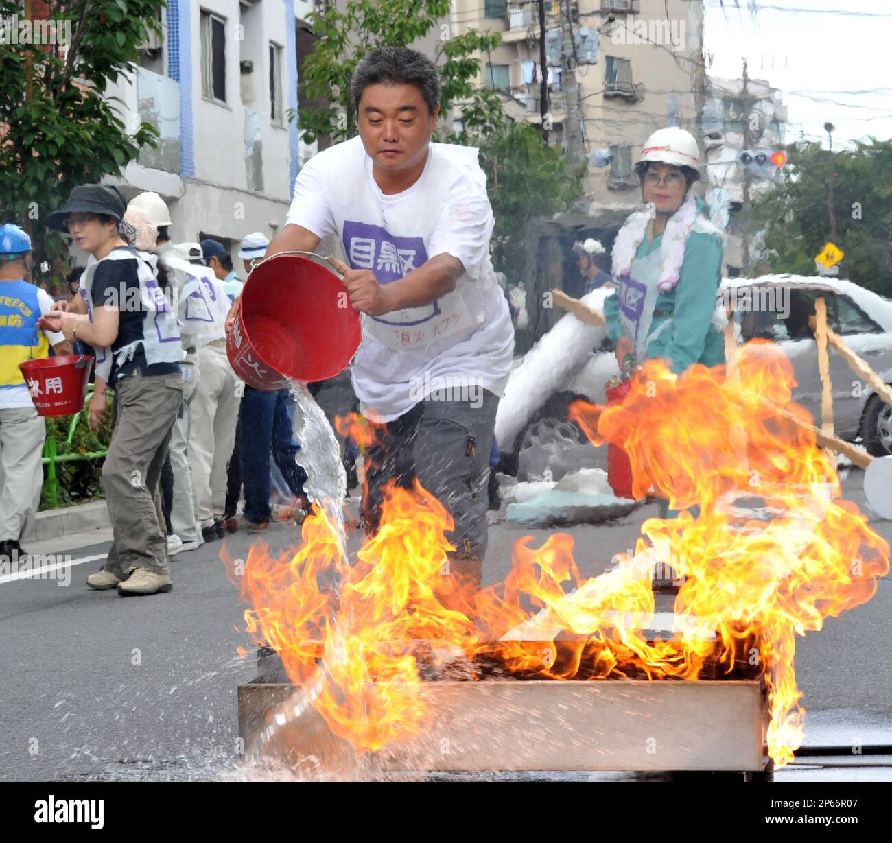 Participants in a disaser drill form a bucket brigade to extinguish a ...