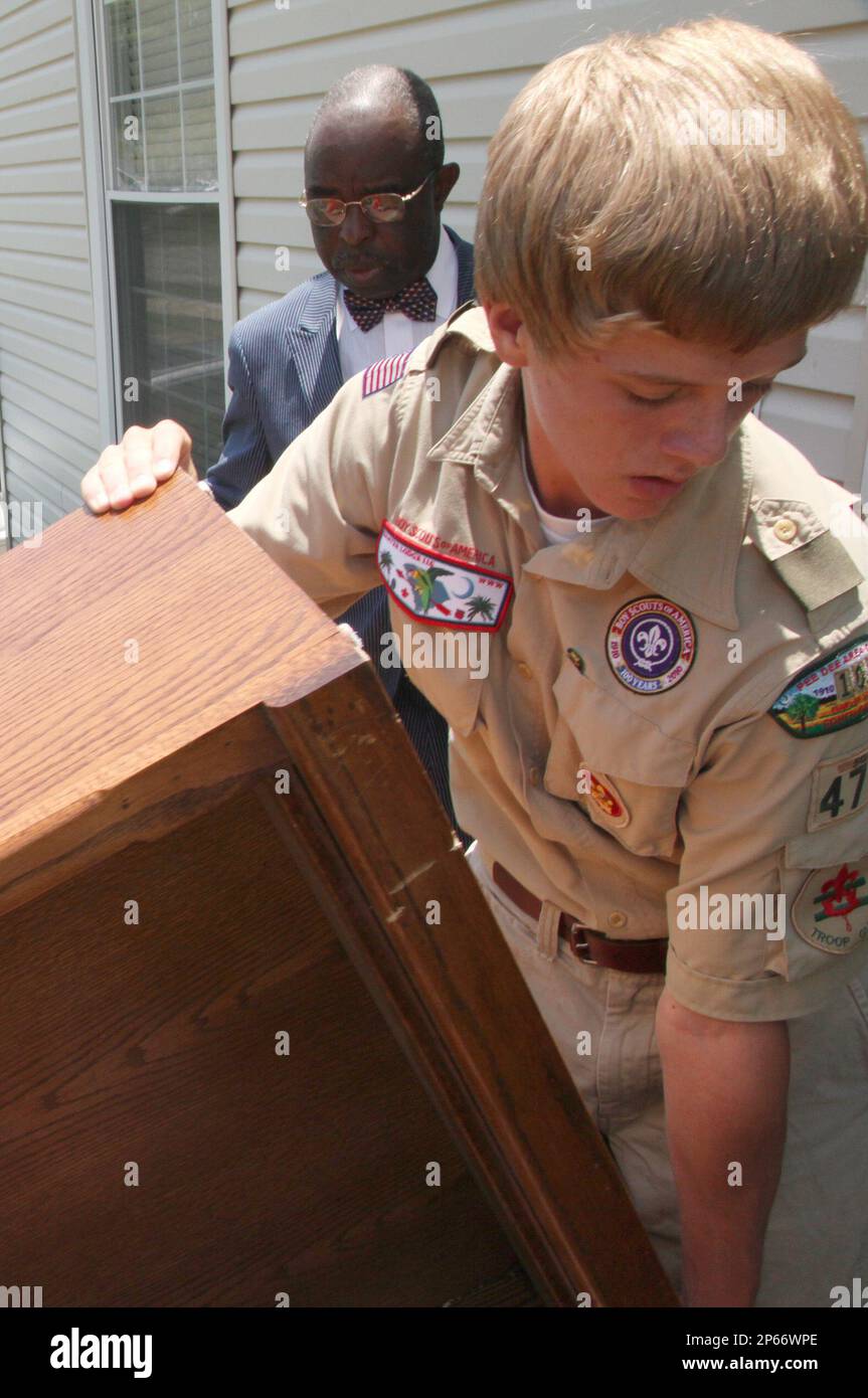 In this undated photo, Rev. Mack Hines looks on as Jack Pawloski carries one of several book ...