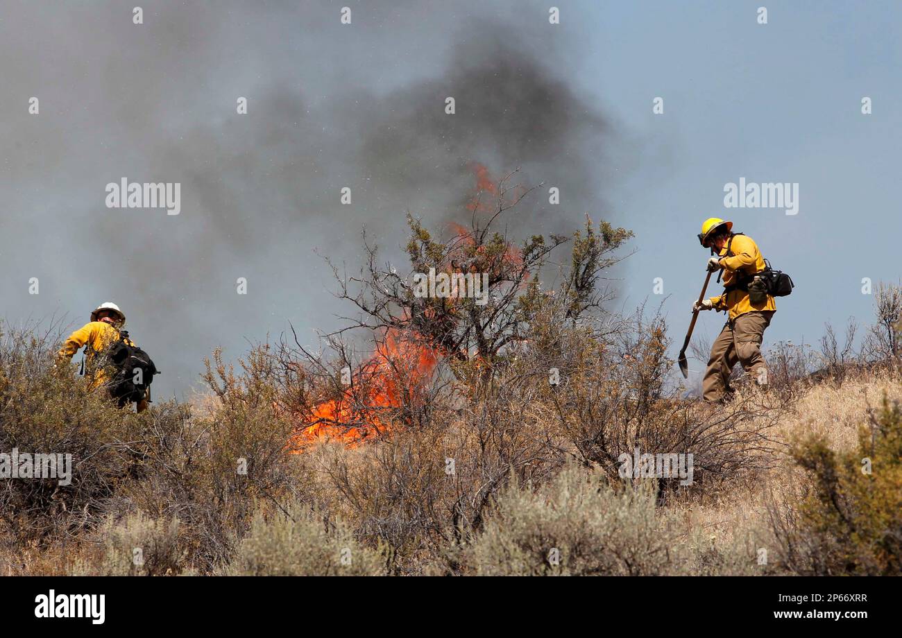 Hand crews dig line around a wildfire as it burns in the Wenas Lake ...