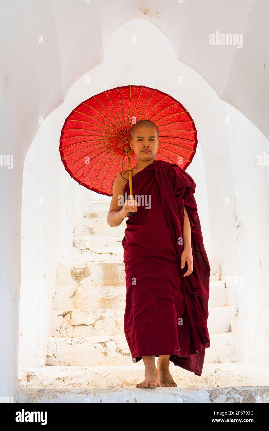 Novice monk with umbrella standing at staircase hallway at Hsinbyume ...