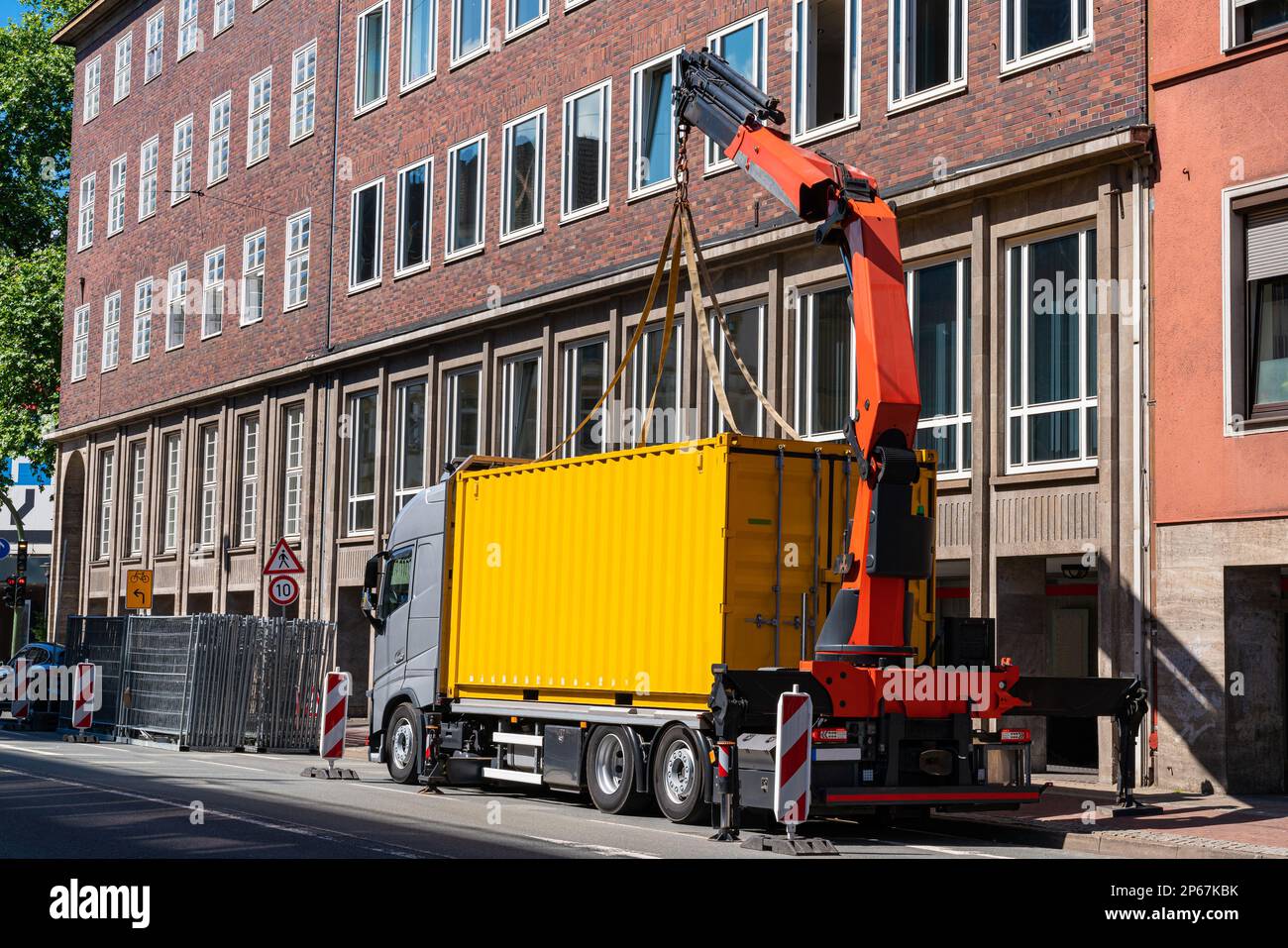 Unloading a large yellow container from a truck. Renovation of a large ...