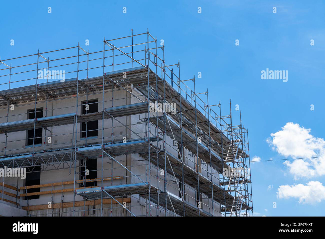 Building under construction surrounded by scaffolding against the blue ...