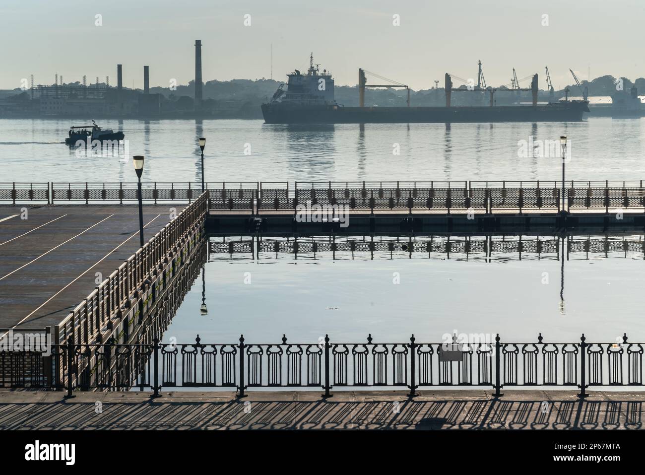 Symmetrical patterns of railings, a boat, a ship and cranes at Havana ...