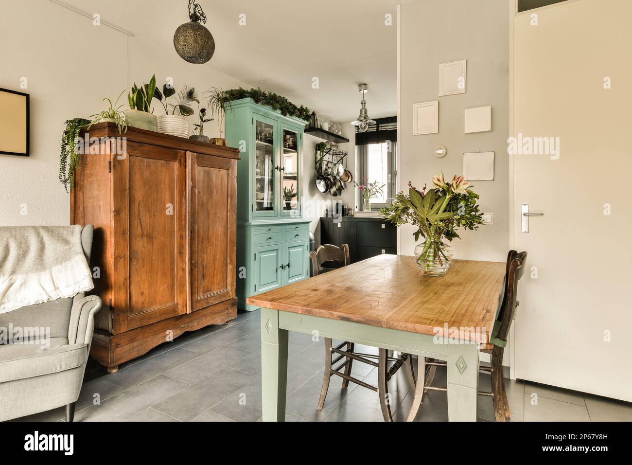 a living room with a table and chair in front of the couch, which is ...