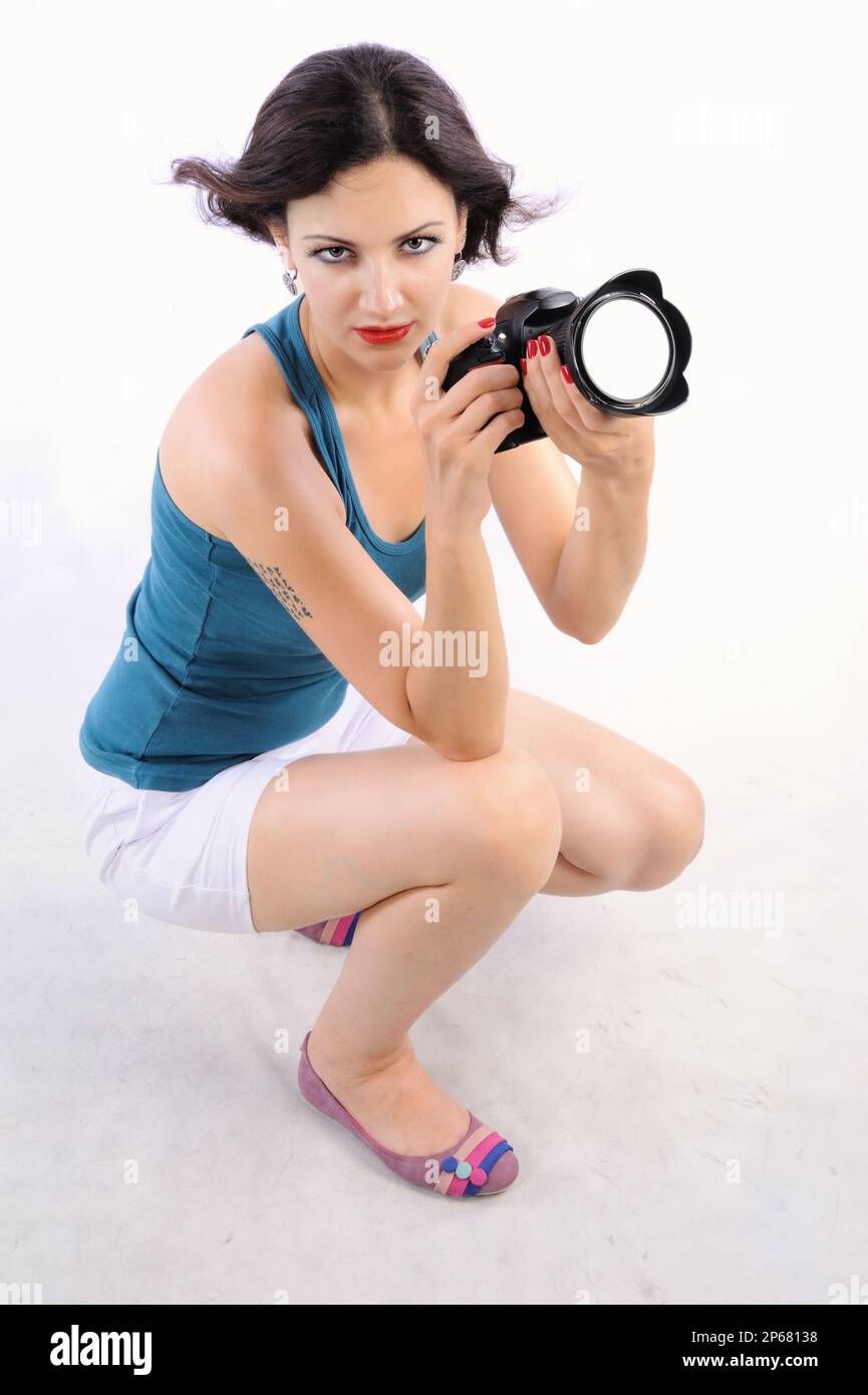 beautiful young woman with a DSLR camera in studio Stock Photo - Alamy