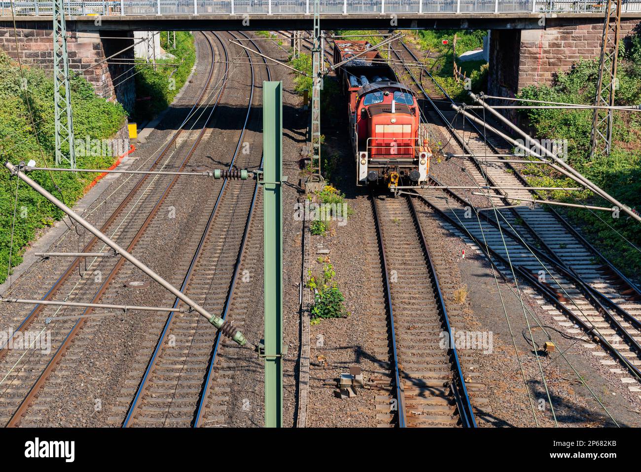 Freight train with wagons loaded with scrap metal passes under the ...
