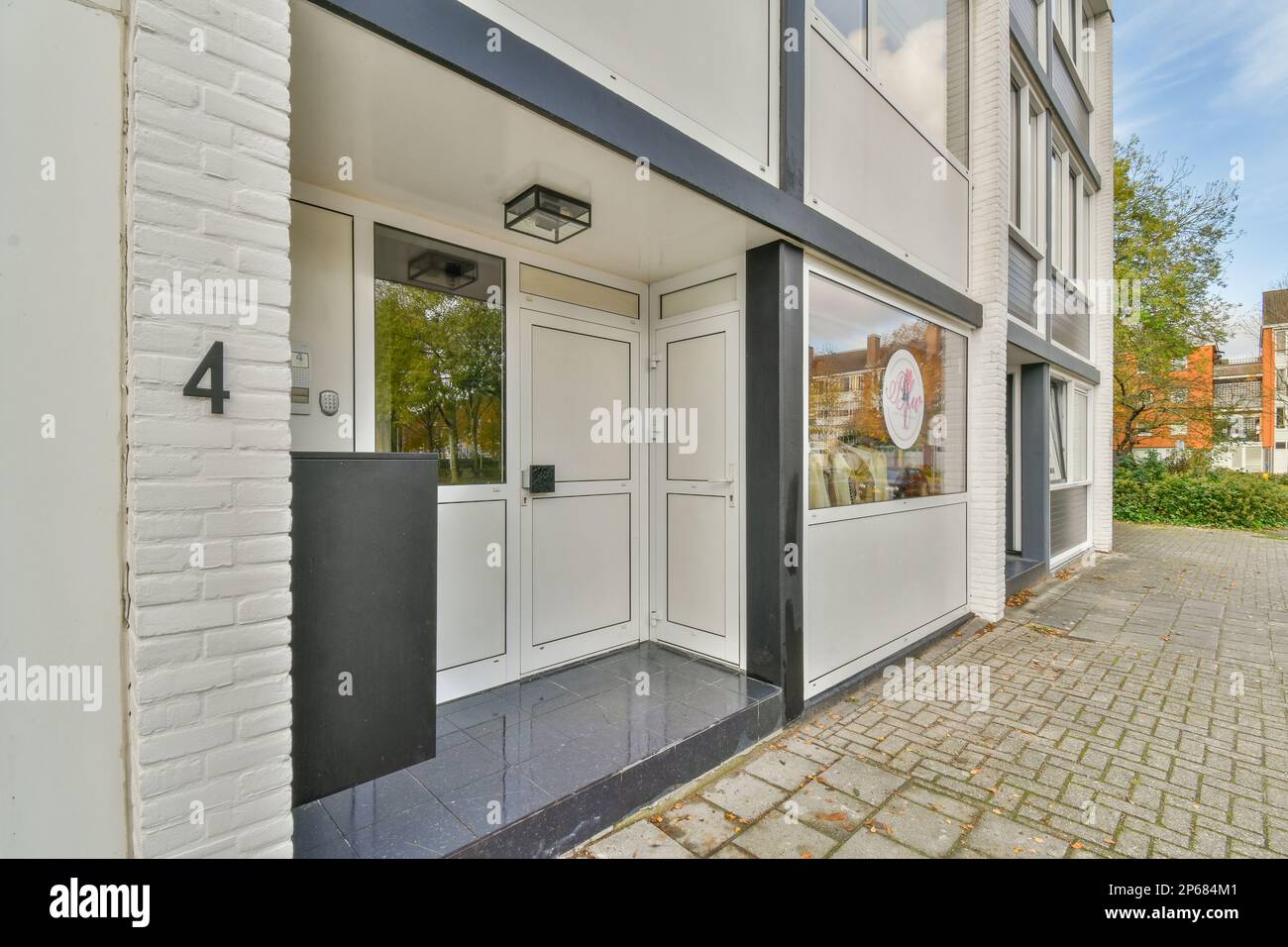 the outside of a building with white doors and black trim on it's ...