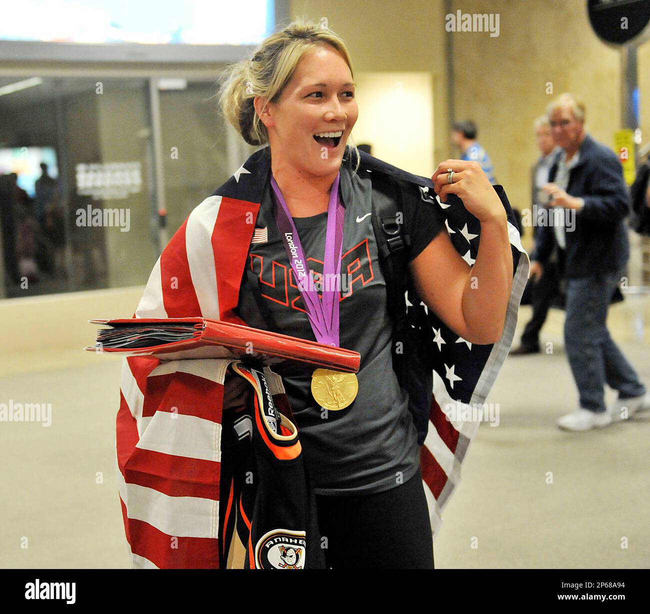 Water polo gold medalist Courtney Mathewson is greeted by friends and ...