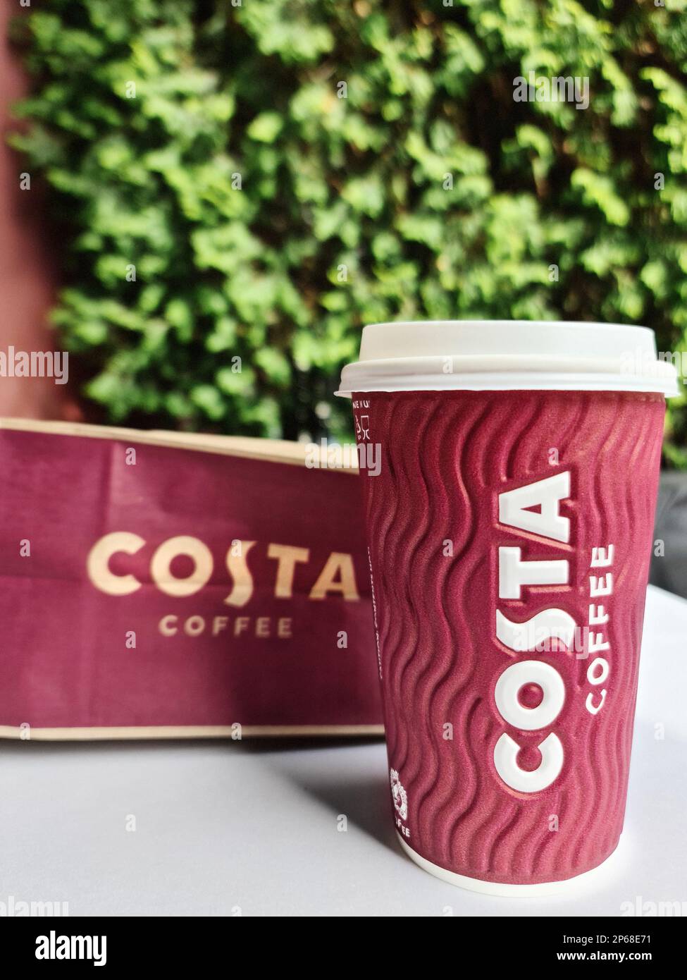 Signature paper cup and paper bag of Costa Coffee on the table of a ...