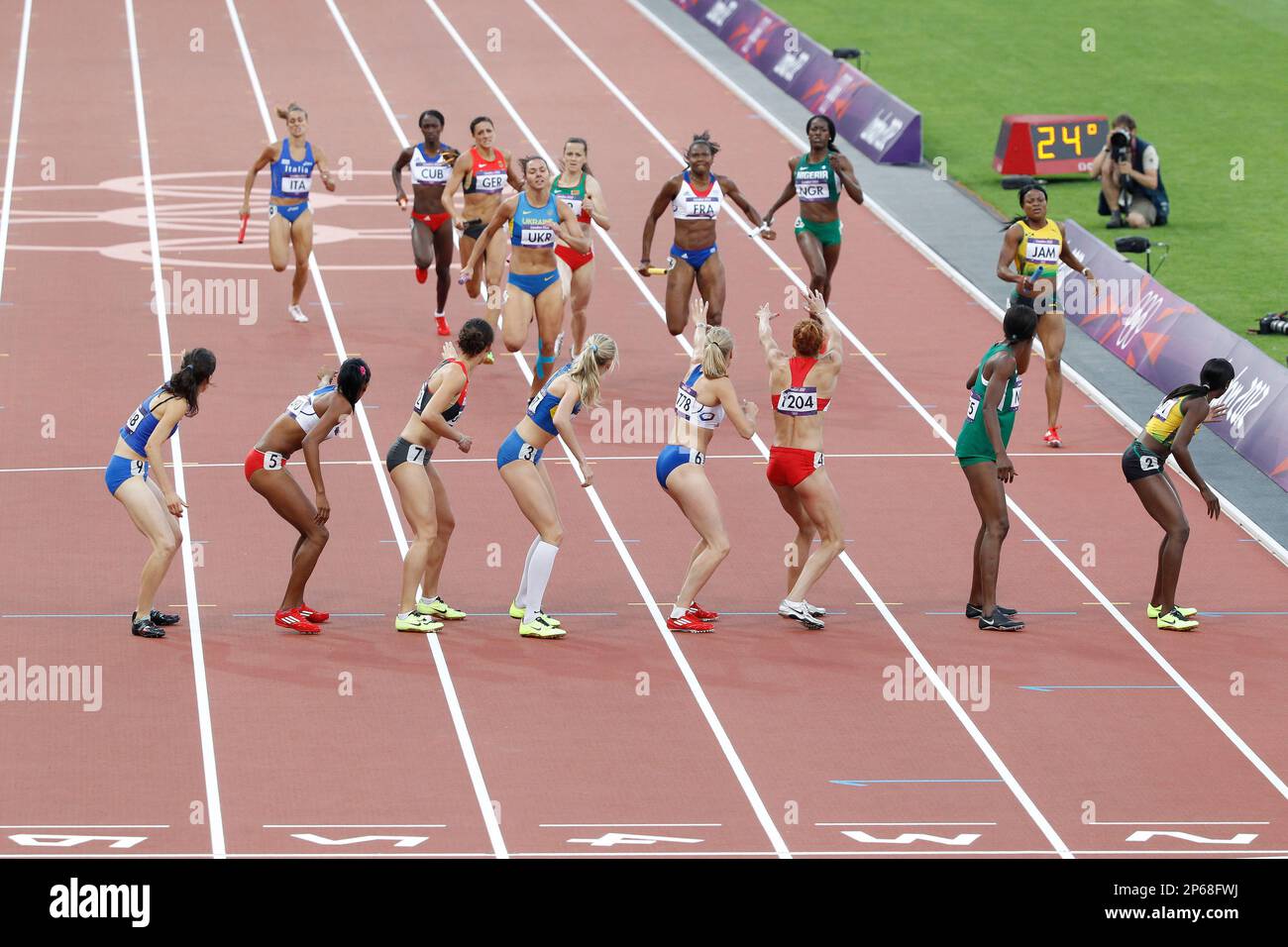 Teams in the Women's 4x400 relay wait to exchange batons at the London ...